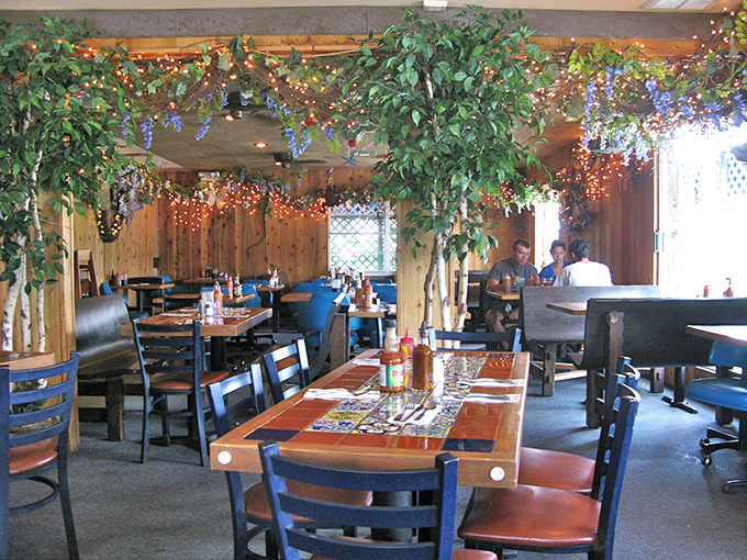 Wooden walls adorned with twinkling lights and greenery create that rare atmosphere where you feel instantly at home, even before the first bite arrives.