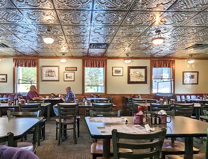 Ornate tin ceiling tiles and cozy booths create that perfect small-town diner atmosphere where conversations flow as freely as the coffee.