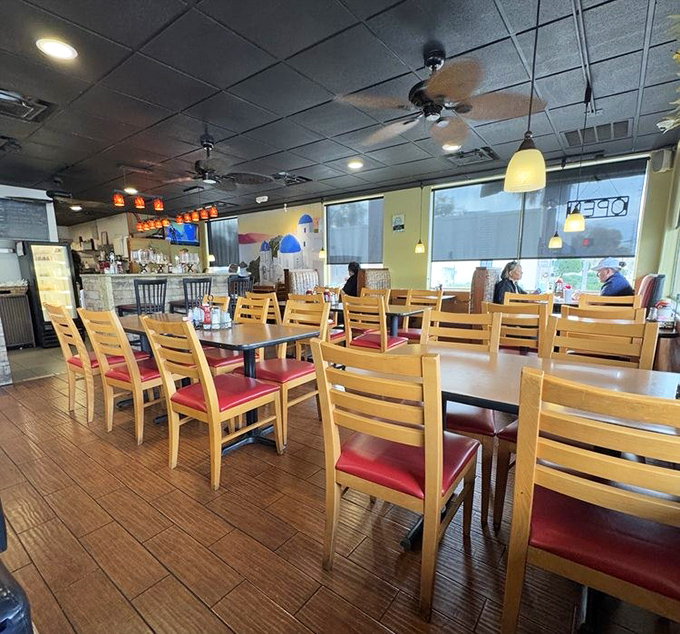 Inside, wooden tables with cherry-red chairs create that perfect "come as you are" vibe where both flip-flops and business shoes feel equally at home.
