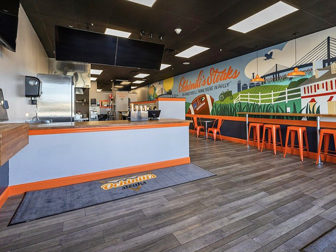 Orange accents and Philadelphia murals create a vibrant atmosphere where comfort food meets contemporary style perfectly.