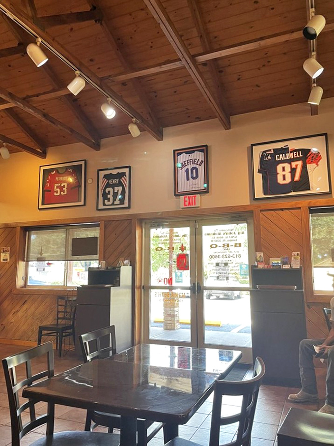 Sports jerseys watch over diners like barbecue guardian angels. The wooden ceiling beams and warm lighting create the perfect setting for serious meat contemplation. 