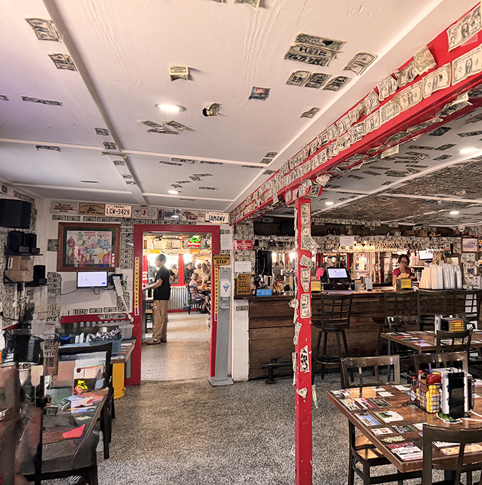 Dollar bills wallpaper every surface, each representing a satisfied customer who left their mark before returning to the real world.