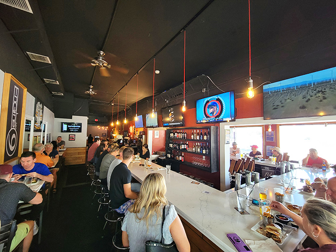 Inside, the narrow space buzzes with energy as diners crowd the bar. Those red pendant lights cast the perfect glow for serious burger contemplation.