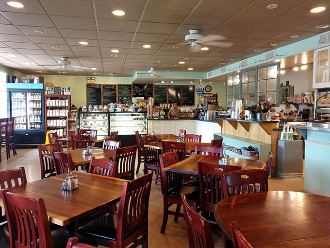 Warm wooden tables, mission-style chairs, and that light blue accent wall create the perfect backdrop for morning conversations and coffee revelations.