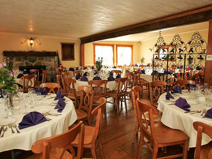 White tablecloths, purple napkins, and a stone fireplace create the perfect backdrop for memorable meals where conversations flow as smoothly as the gravy.