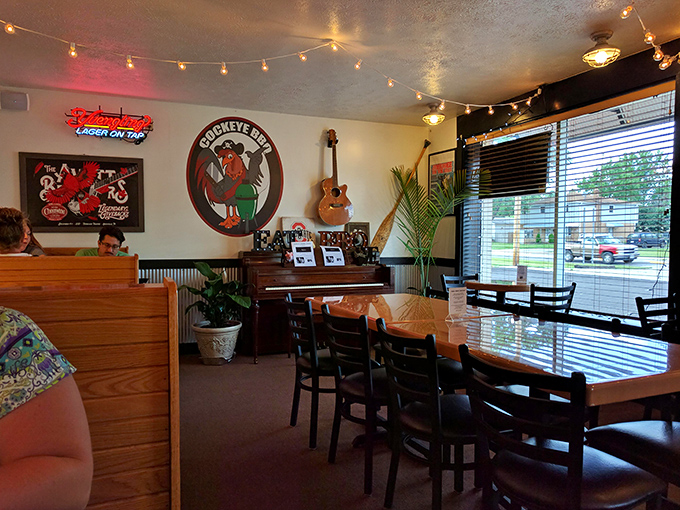 String lights, wooden booths, and that iconic rooster logo create the perfect backdrop for the meat-centric magic about to unfold.