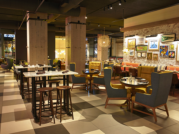 Where rustic meets refined&mdash;exposed brick walls and mustard yellow seating create a space that feels both farmhouse chic and metropolitan cool. 