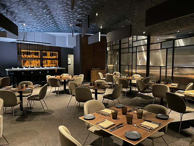 Modern elegance meets steakhouse comfort in a dining room where every table feels like the best seat in the house. That textured ceiling? Conversation starter.