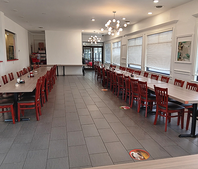 Red chairs and modern chandeliers create that perfect "fancy but not too fancy" vibe where both Sunday best and Saturday sweats feel equally at home.