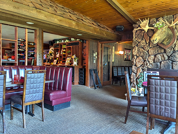Knotty pine, burgundy booths, and a moose keeping watch – the interior embraces northwoods charm without a hint of pretension.