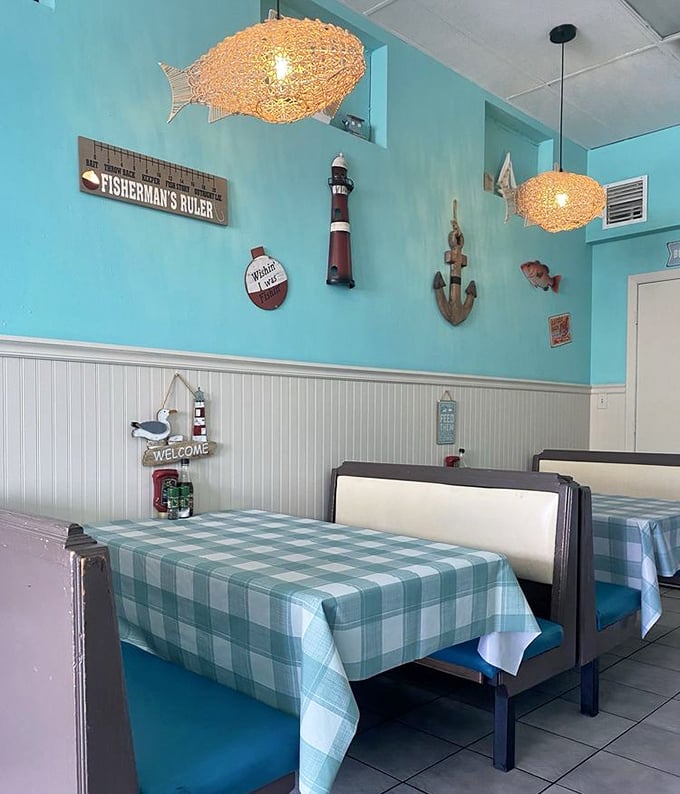 Nautical nirvana in turquoise and white. Those fish-shaped pendant lights aren't just illuminating the room—they're setting the mood for the oceanic feast that awaits.