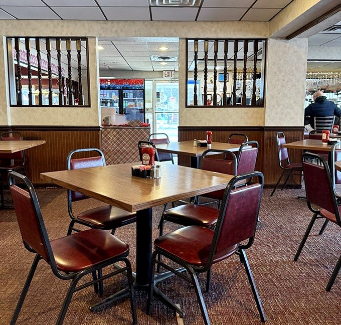 Classic diner aesthetics with wood paneling and vinyl chairs—where comfort trumps trendiness and conversations flow as freely as the coffee.