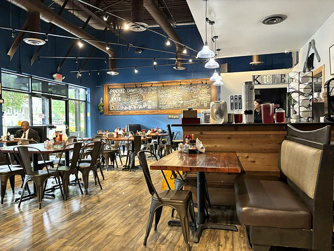 Industrial meets cozy inside Oy!, where blue walls, wooden tables, and pendant lighting create the perfect backdrop for breakfast magic to unfold.