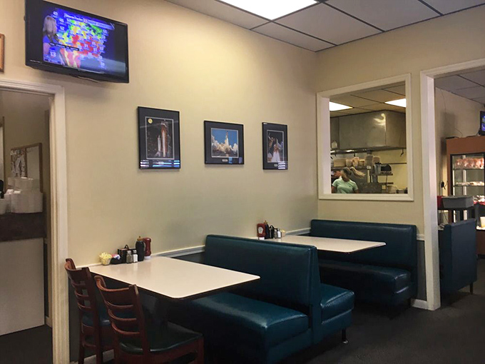 Classic blue booths and simple tables set the stage for culinary magic, while space shuttle photos remind you that rocket scientists need good breakfasts too.