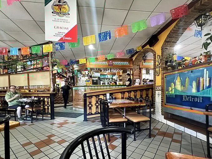 Step inside and the fiesta begins! Colorful papel picado banners dance overhead while the Detroit skyline mural reminds you this authentic Mexican experience has Michigan roots.