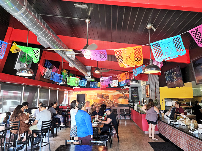 Festive papel picado banners dance overhead as diners commune in carnitas bliss. The vibrant interior matches the lively flavors that have made this spot legendary.