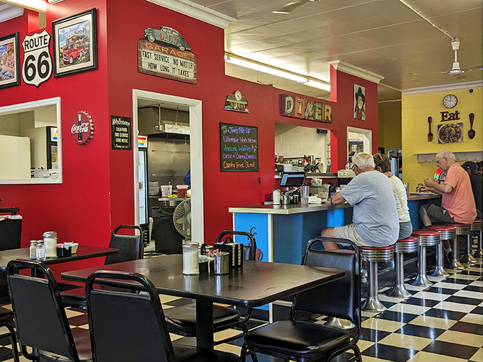 Classic Americana comes alive with vibrant red walls, Route 66 memorabilia, and a checkerboard floor that practically screams "good food happens here!"