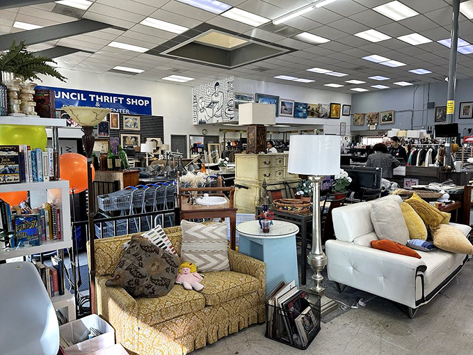 Furniture democracy in action – a vintage yellow floral sofa shares floor space with a sleek white contemporary piece, both waiting for their second act.