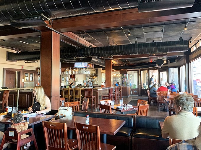 Inside, warm wooden tones and exposed ductwork create that perfect "upscale casual" vibe where both flip-flops and fancy shoes feel equally at home.