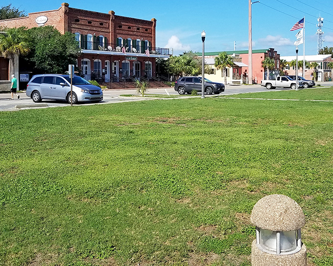 Stately brick buildings frame Market Street's green space, where American flags flutter in the Gulf breeze and history whispers from every corner.