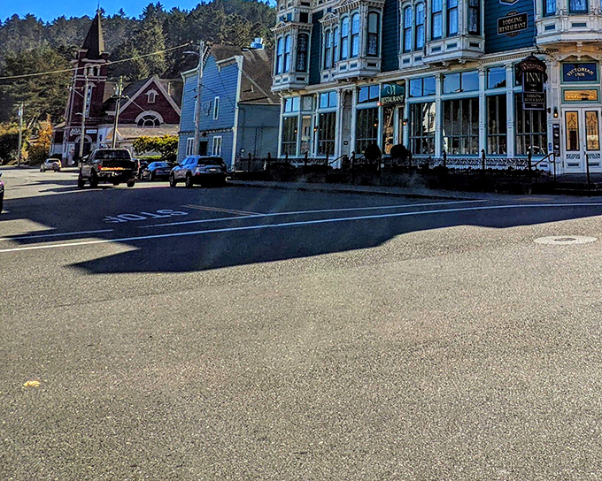 The Victorian Inn stands sentinel against forested hills, while a church steeple peeks through the skyline&mdash;quintessential Americana in architectural form.