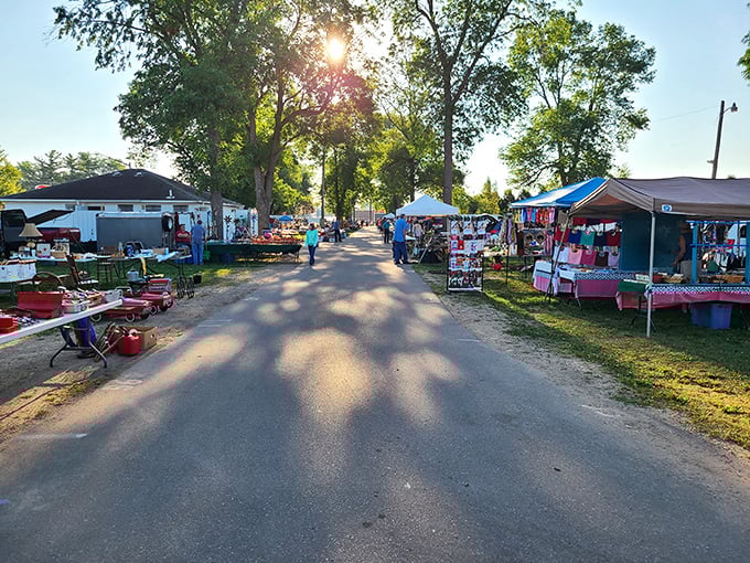 Early morning magic at the flea market, where dappled sunlight guides shoppers down pathways of possibility between neatly arranged vendor stalls.