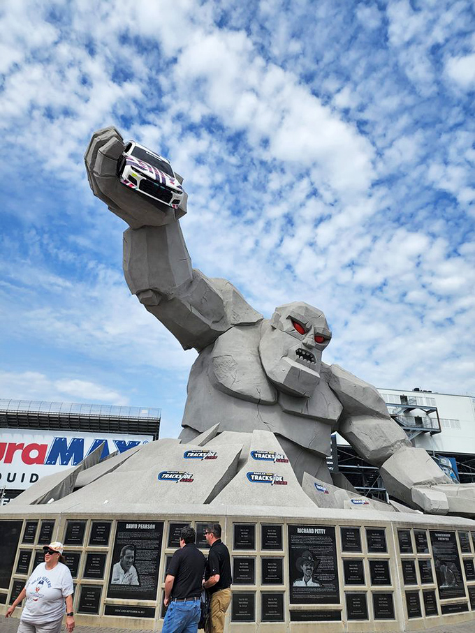 Is that thing holding my car? Visitors marvel at the 46-foot monument while racing legends immortalized on plaques silently observe the spectacle.