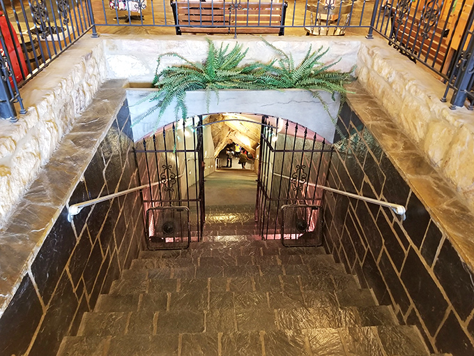 The descent beckons with wrought-iron gates and stone steps, like entering a fantasy novel where the adventure happens below ground rather than above.