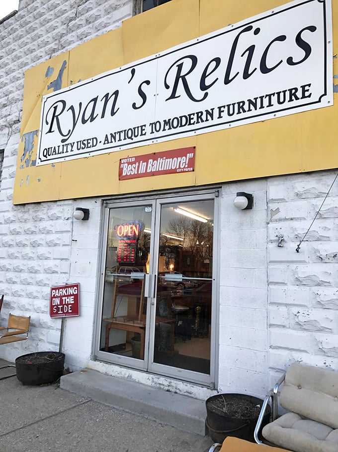 "Quality Used - Antique to Modern Furniture" promises a time-traveling experience. The yellow sign against stone walls hints at Baltimore's best-kept secret.