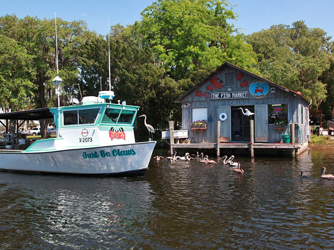 Old Florida charm at its finest! The Fish Market's weathered wood exterior and the aptly named "Just Be Claws" boat create a postcard-perfect scene.