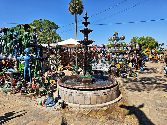 This elegant fountain stands as the centerpiece of organized chaos, like a dignified maestro conducting an orchestra of colorful garden sculptures.