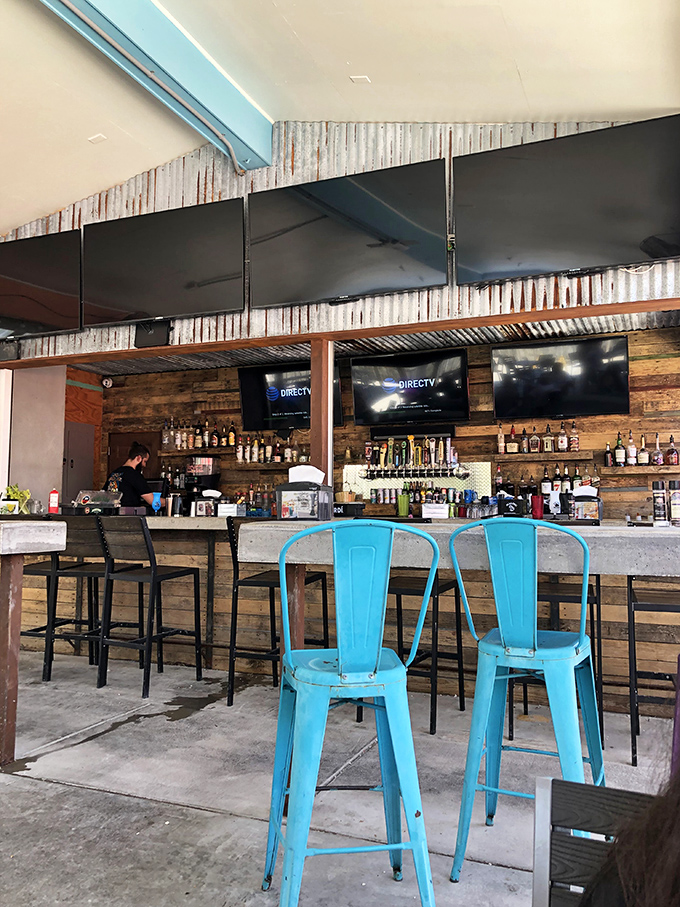 Rustic meets coastal at the bar, where turquoise chairs pop against weathered wood paneling&mdash;Florida's version of industrial chic.