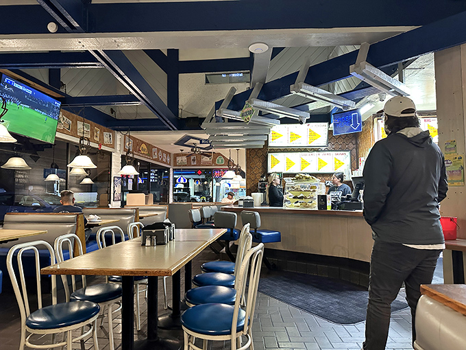 Blue vinyl chairs and navy ceiling beams create that perfect old-school diner atmosphere where sports play on TVs and conversations flow as freely as the coffee.