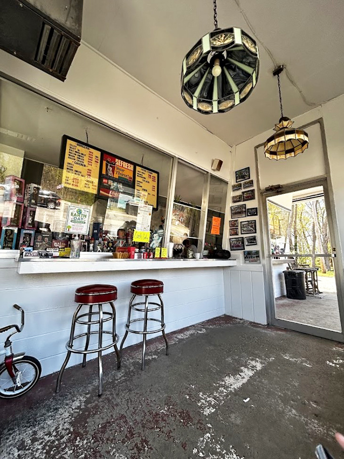 Step inside and you're transported to simpler times, where vintage pendant lights cast a warm glow over red bar stools that have witnessed countless hungry smiles.
