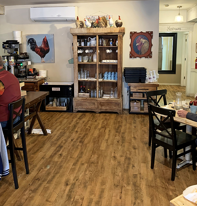 Rustic wooden floors, rooster-themed d&eacute;cor, and that cabinet of curiosities create the perfect backdrop for breakfast bliss. Farmhouse chic meets culinary excellence.