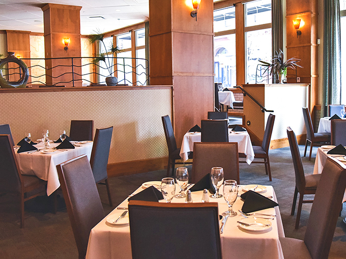 White tablecloths and warm wood tones create an atmosphere that says "special occasion" without whispering "second mortgage required."