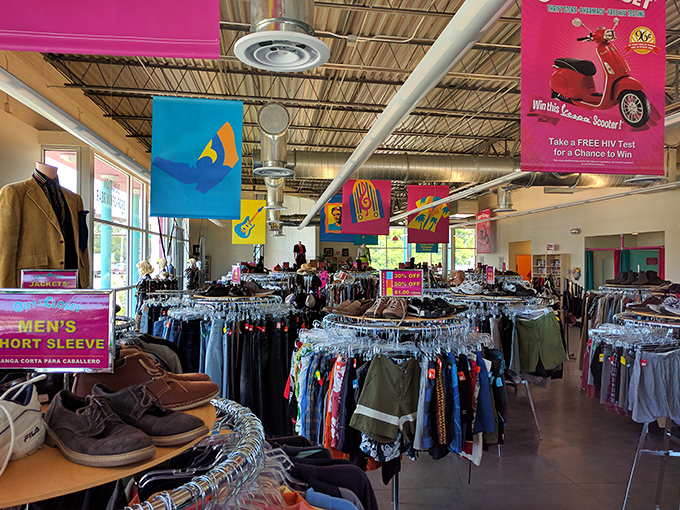 Treasure hunting begins here, where colorful banners guide shoppers through a sea of possibilities. The organized chaos of racks promises discoveries for those patient enough to look.