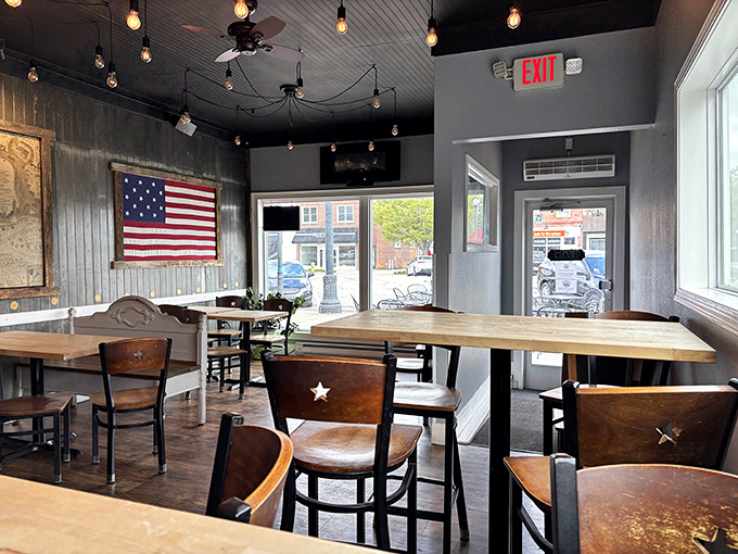 Edison bulbs cast a warm glow over wooden tables and star-adorned chairs, creating an atmosphere that feels like Americana distilled into restaurant form.