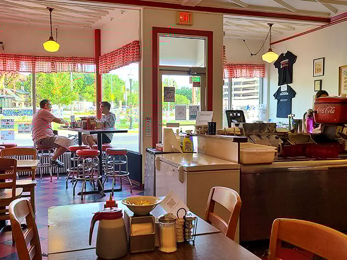 Morning light streams through checkered curtains, illuminating a diner where conversations flow as freely as the coffee. This isn't decoration&mdash;it's authentic history.