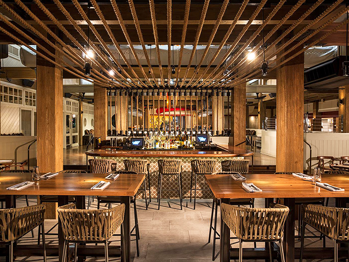 Exposed wooden beams, woven chairs, and warm lighting create the perfect backdrop for seafood indulgence. Like a stylish yacht club where everyone's welcome.