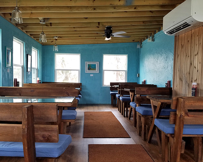 Coastal vibes meet comfort in this no-frills dining room. Blue walls, wooden booths, and natural light create the perfect backdrop for seafood magic.