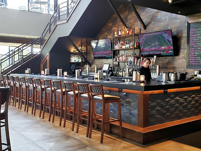 The sleek bar area invites patrons to linger over craft beers and conversation, proving that waiting for a table can be half the fun.