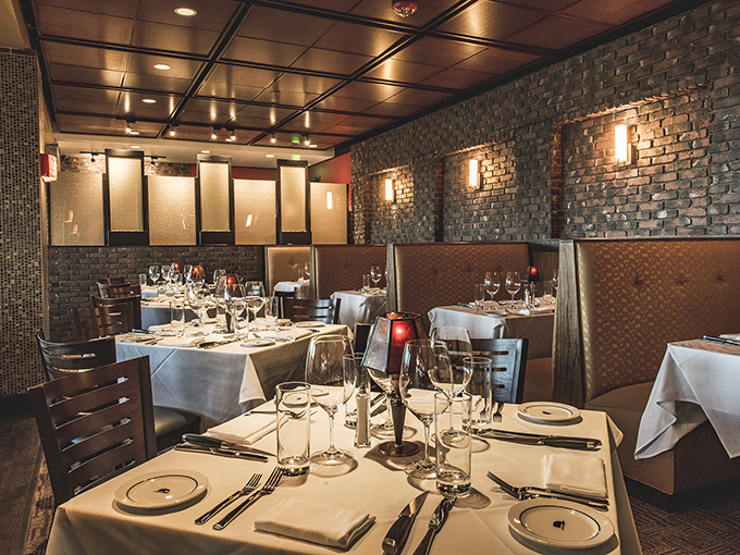 Exposed brick walls and leather booths create that classic steakhouse vibe where you half expect Frank Sinatra to walk in and request his usual table.