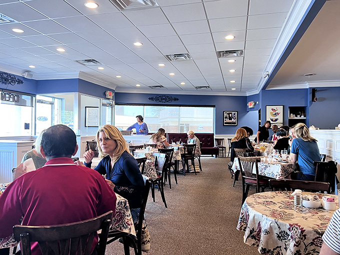Morning conversations and coffee refills flow freely in this cozy blue-walled sanctuary. The floral tablecloths? Pure Michigan breakfast charm.