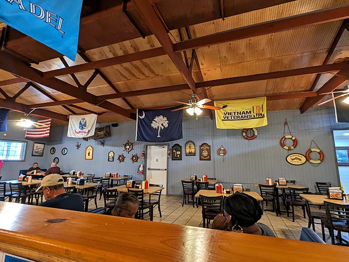 Nautical charm meets Southern hospitality under wooden beams, where state flags and maritime memorabilia create the perfect backdrop for seafood feasting.