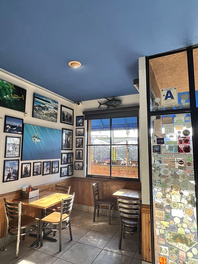 Ocean-blue ceiling and fishing photos transform this cozy corner into an underwater dining adventure. The walls tell stories of epic catches and maritime memories.