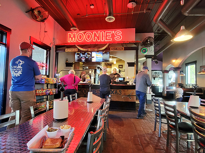 Step inside to the warm glow of Moonie's neon sign, where the red ceiling and metal tables create the perfect backdrop for meat-based memories in the making.