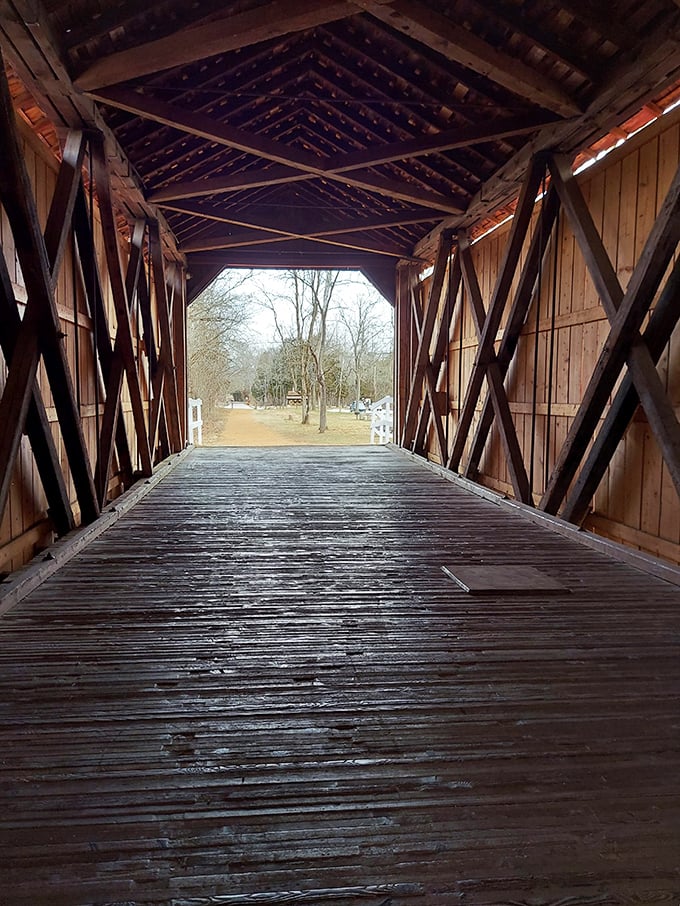 Inside the bridge, a masterclass in 19th-century engineering reveals itself&mdash;crisscrossing wooden trusses creating a geometric dance of shadows and light.