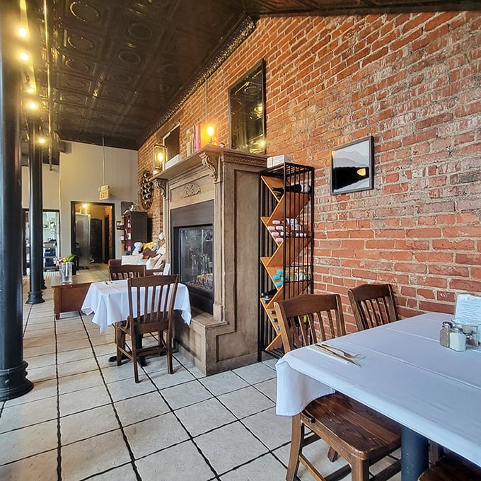 Exposed brick walls meet elegant white tablecloths in this dining room where history and haute cuisine shake hands. That fireplace has witnessed countless memorable meals.
