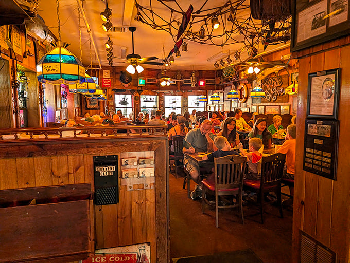 The warm glow of Tiffany-style lamps illuminates happy families diving into seafood feasts. Maritime magic in every corner!